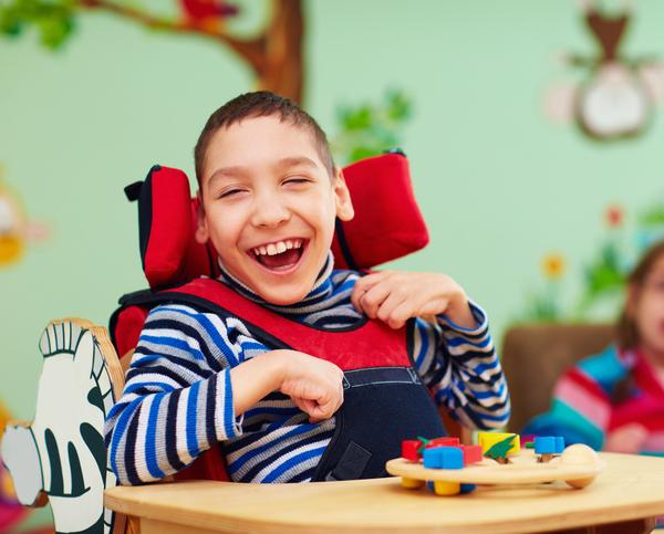cheerful boy with disability at rehabilitation center for kids with ...